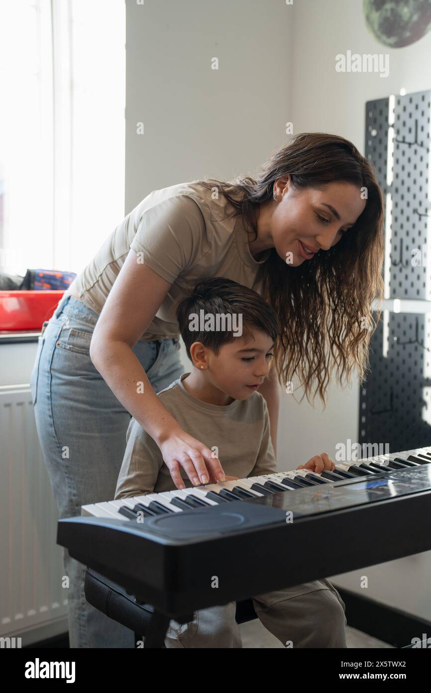 Mother and son (6-7) playing music keyboard at home Stock Photo - Alamy