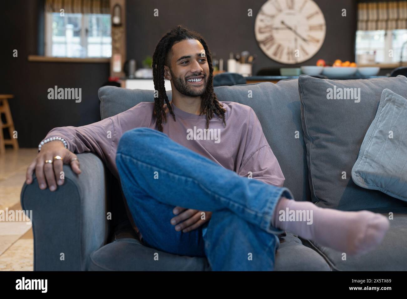 Handsome man with dreads relaxing on sofa Stock Photo - Alamy