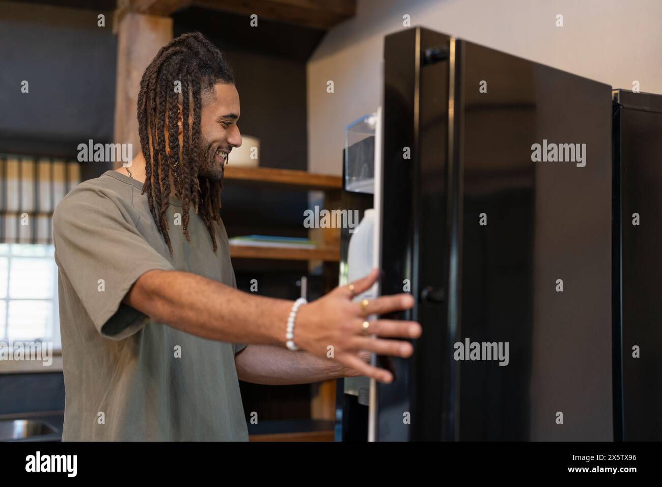 Man standing next to open fridge Stock Photo - Alamy