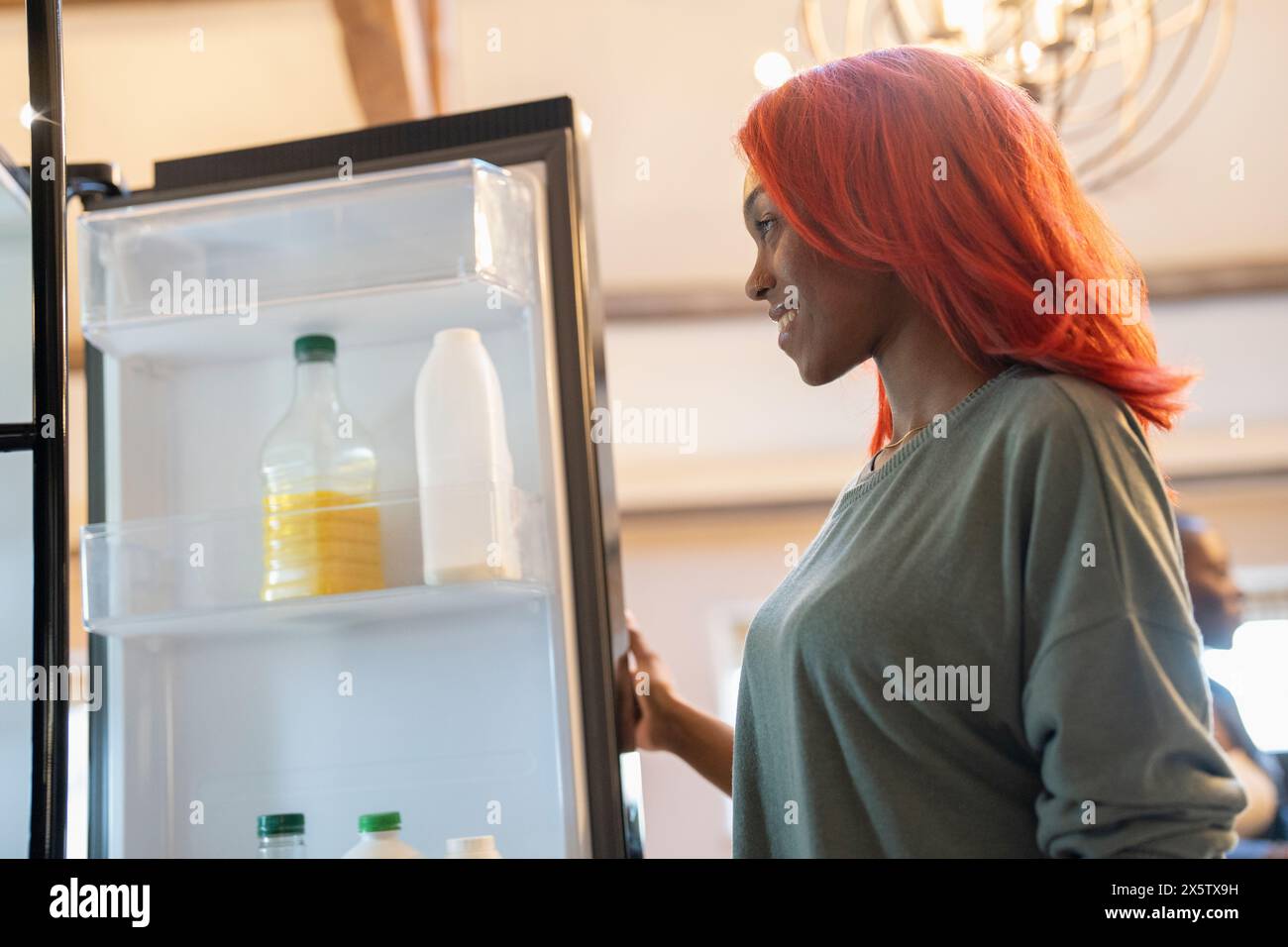 Woman standing next to open fridge Stock Photo - Alamy