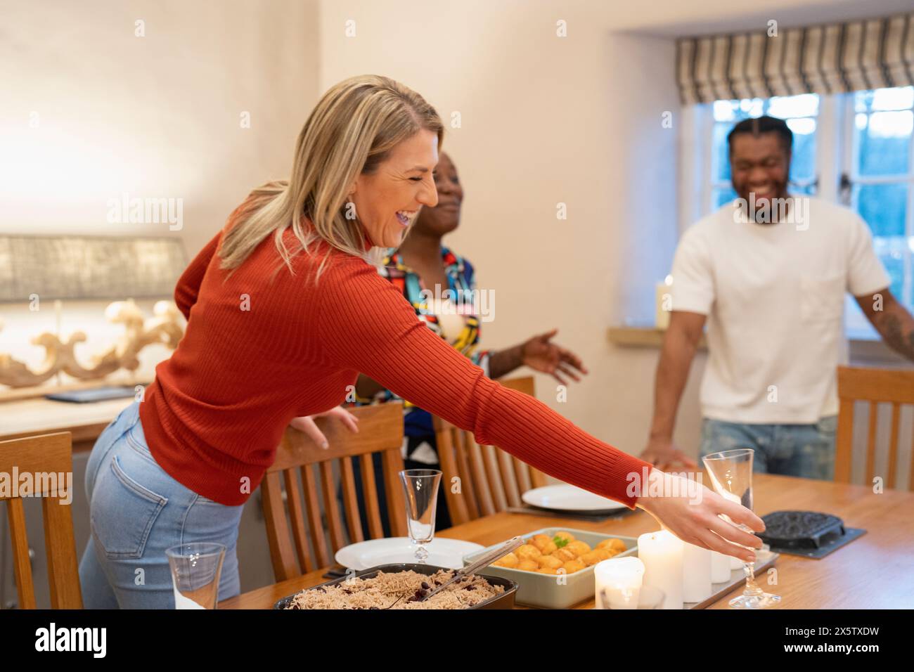 Friends laughing together at dining room Stock Photo - Alamy