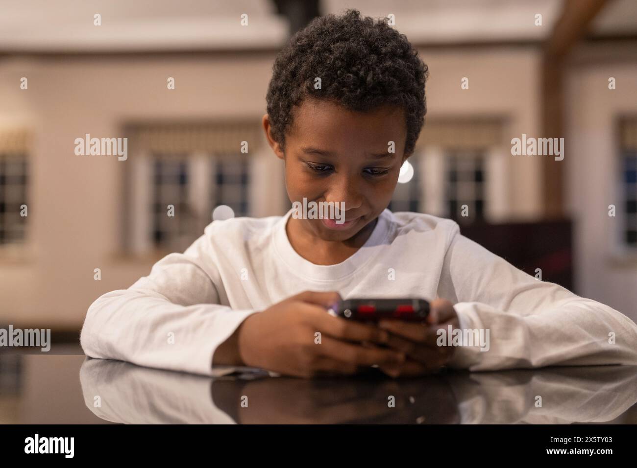 Boy using smart phone at home Stock Photo - Alamy