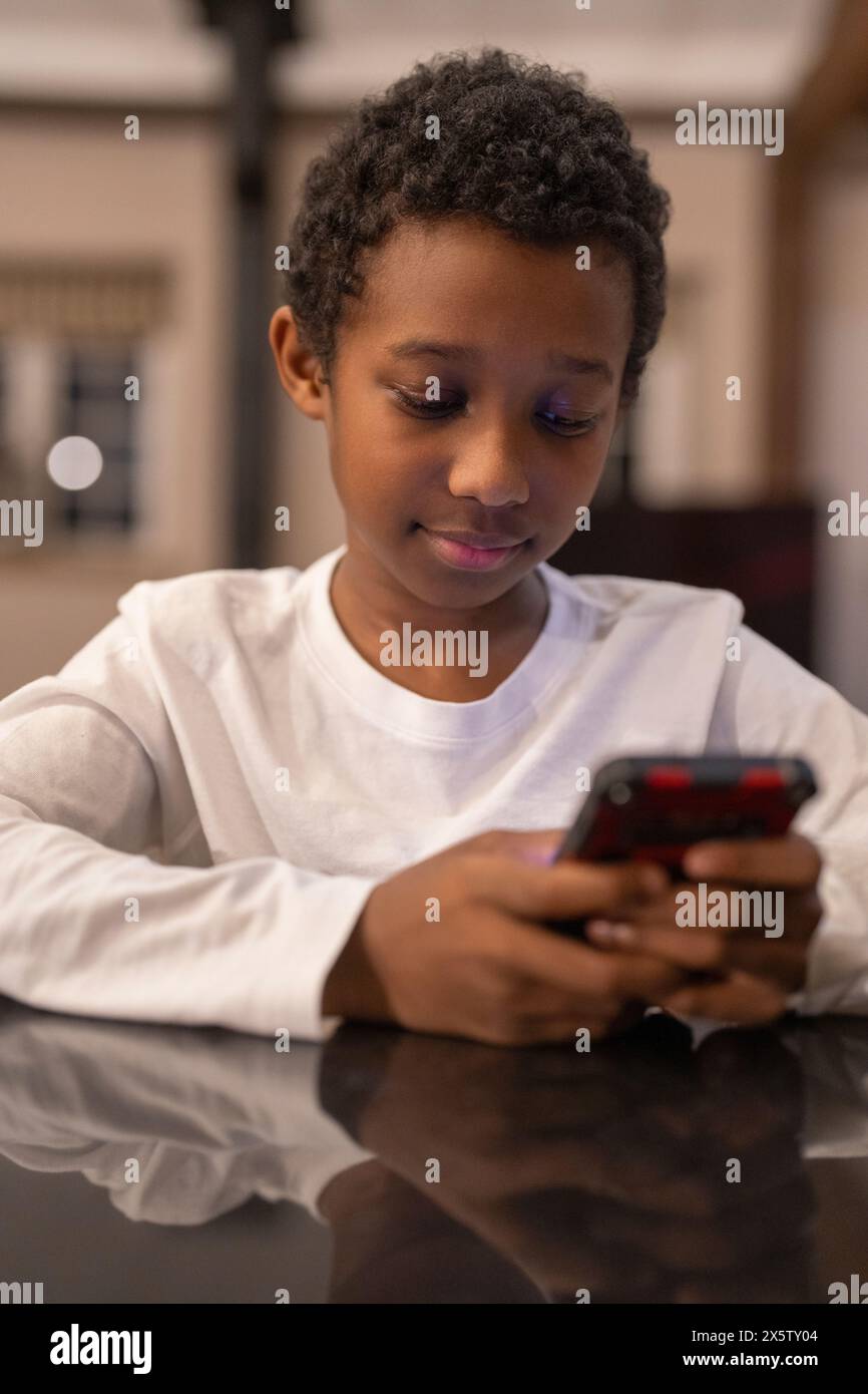 Boy using smart phone at home Stock Photo - Alamy