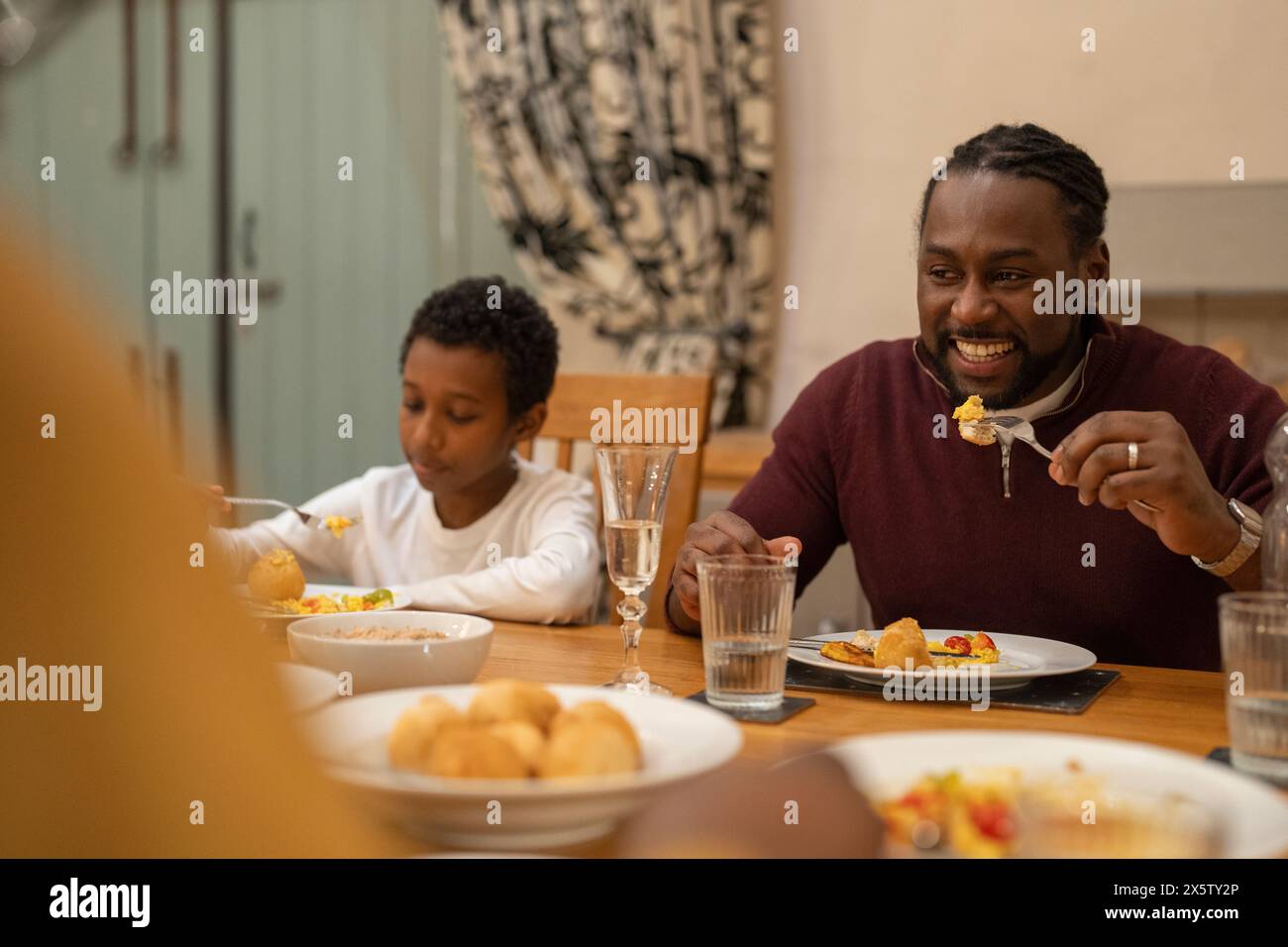 Father and son eating dinner together at home Stock Photo - Alamy