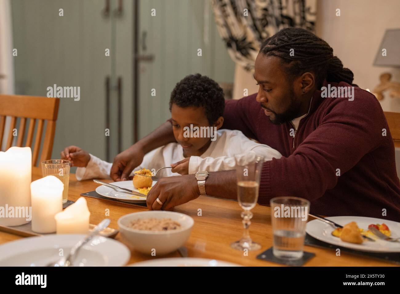 Father and son eating dinner together at home Stock Photo - Alamy