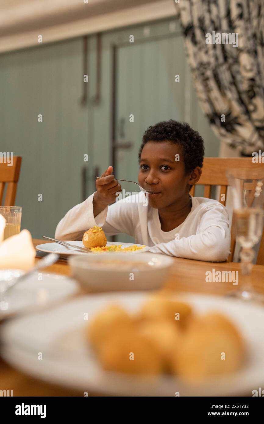 Boy eating dinner at home Stock Photo - Alamy