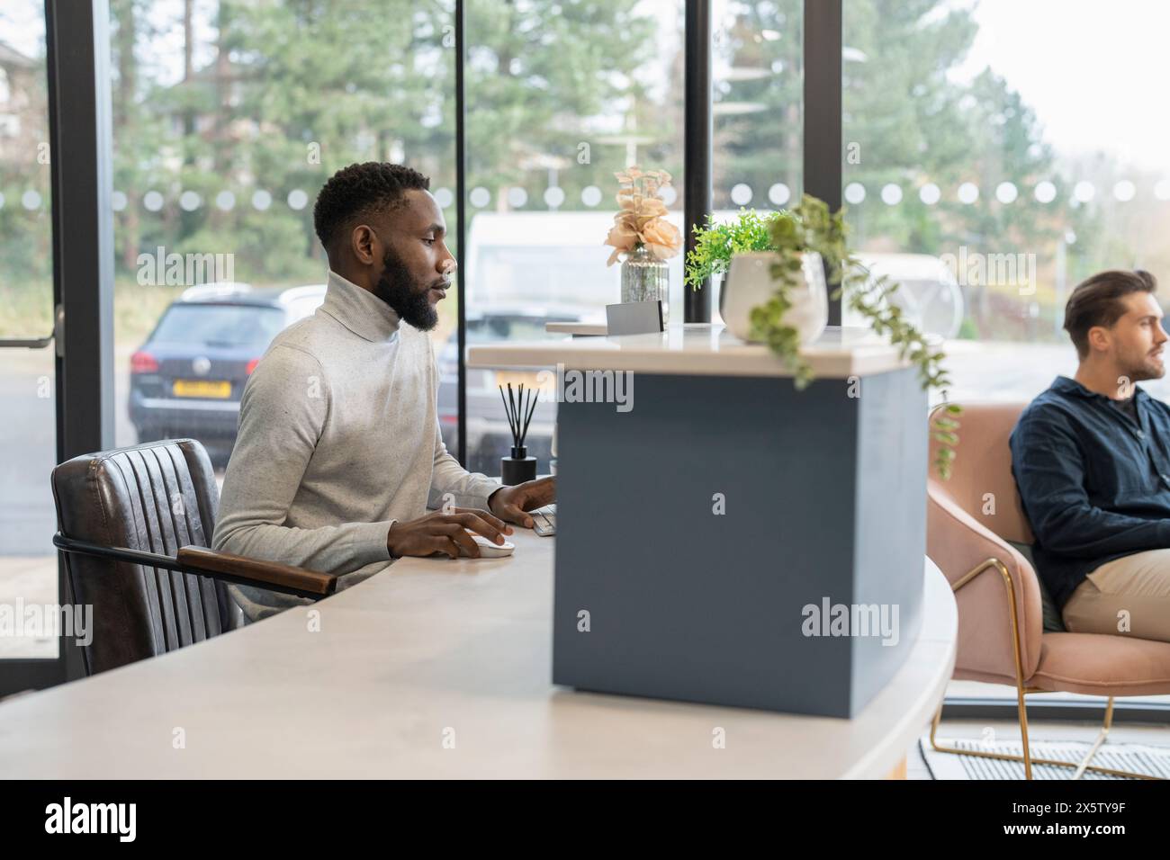 Male receptionist working in office Stock Photo - Alamy