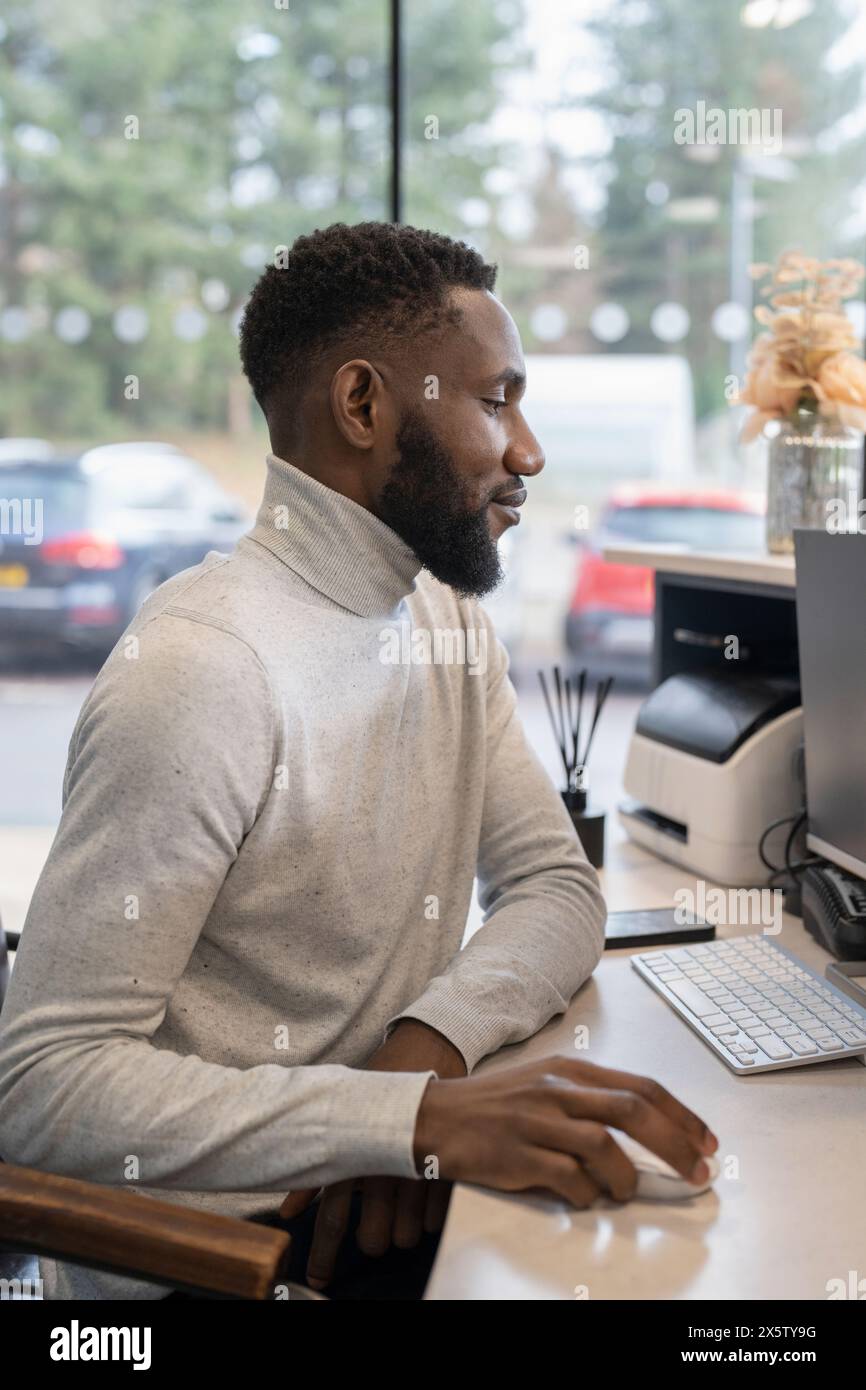 Male receptionist working in office Stock Photo - Alamy
