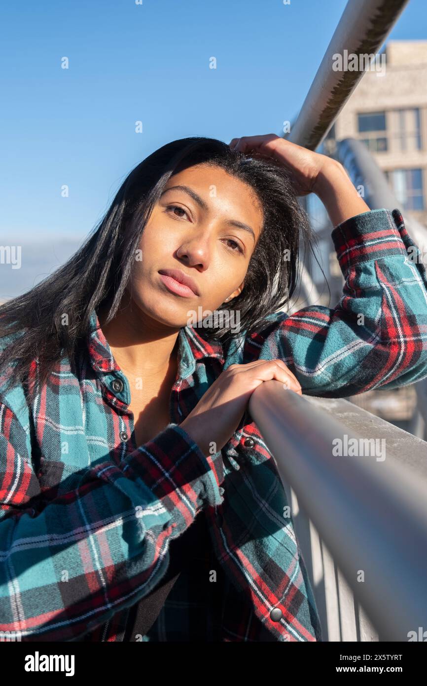 Portrait of woman leaning on railing Stock Photo - Alamy