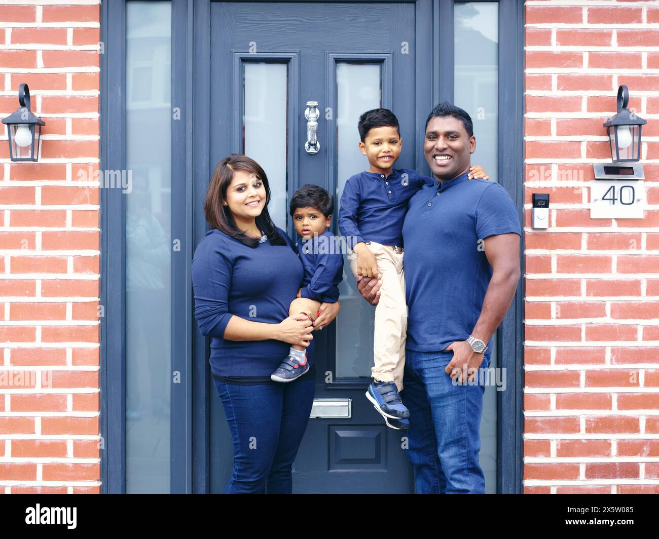 Portrait of family with sons standing on doorstep Stock Photo - Alamy