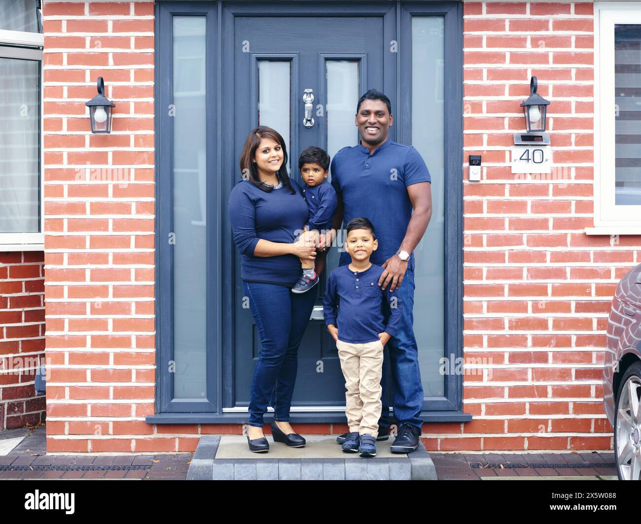 Portrait of family with sons standing on doorstep Stock Photo - Alamy