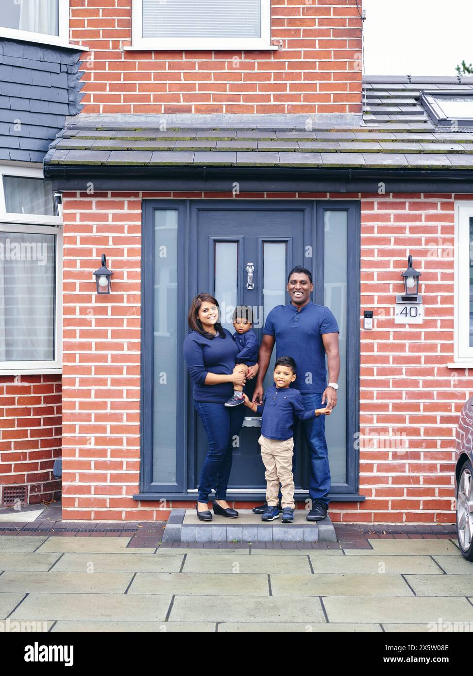 Portrait of family with sons standing on doorstep Stock Photo - Alamy