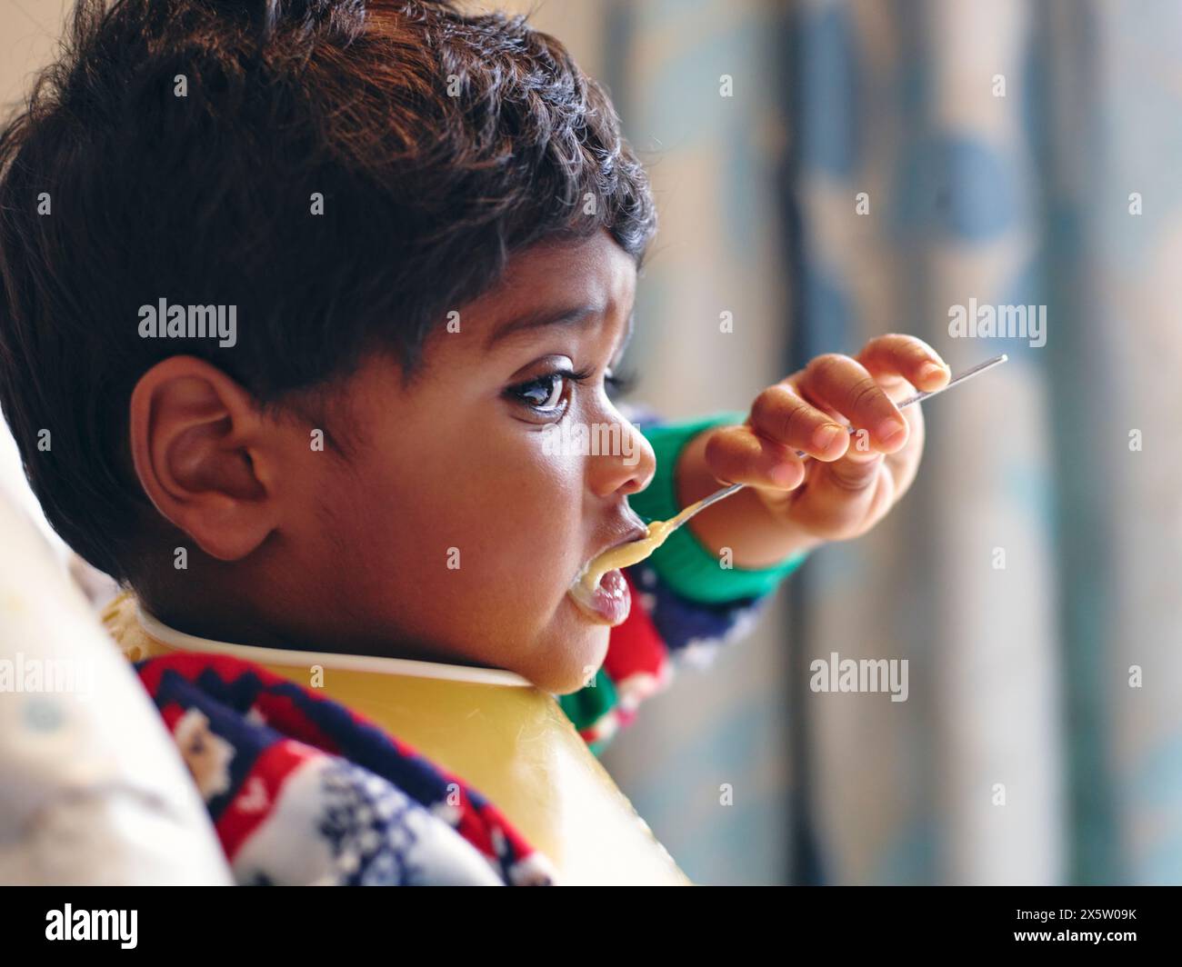 Boy eating with spoon Stock Photo - Alamy