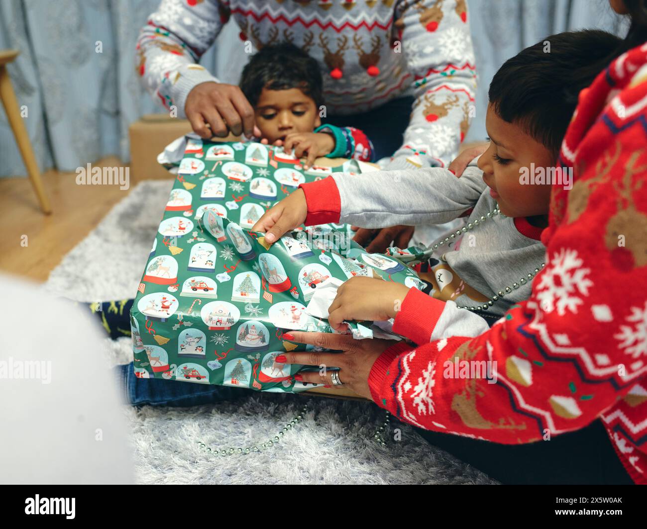 Family with sons opening Christmas presents Stock Photo - Alamy
