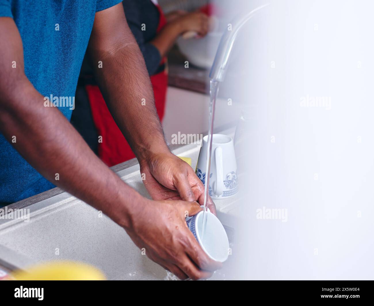 Man washing dishes in kitchen sink Stock Photo - Alamy