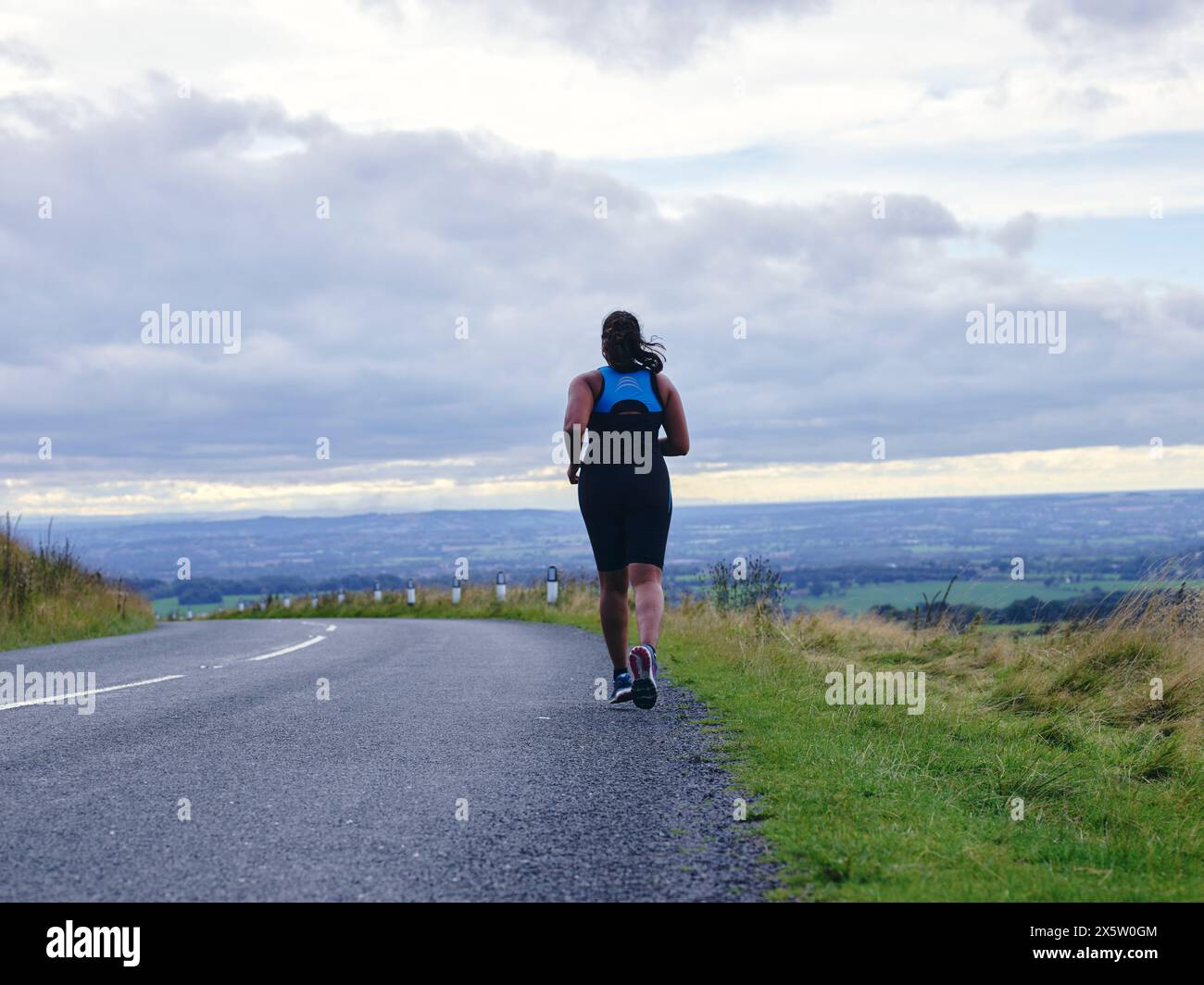 Female runner running on road hi-res stock photography and images - Alamy