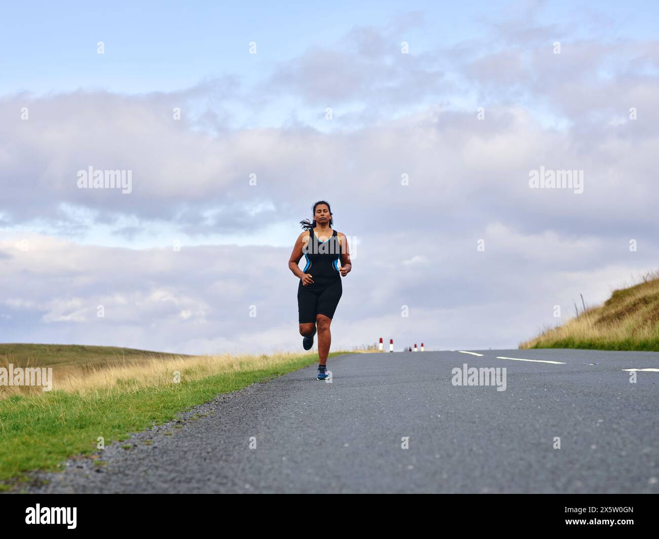 Female runner on country road Stock Photo - Alamy