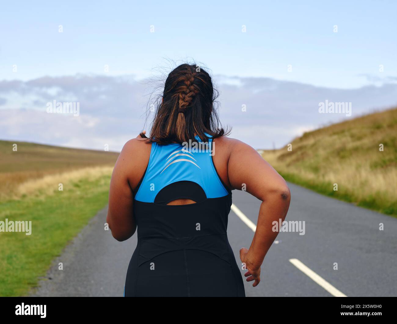 Female runner on country road Stock Photo - Alamy