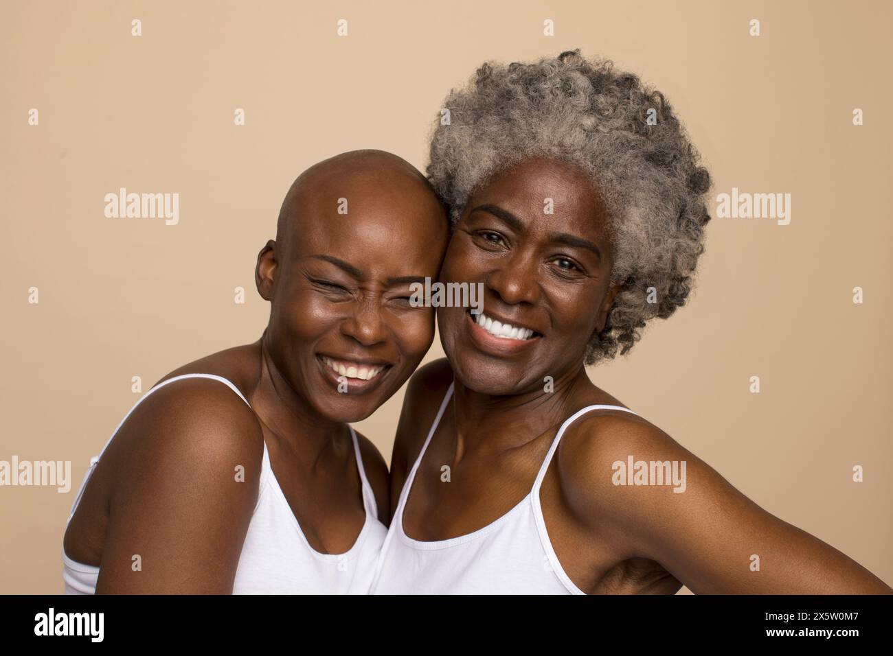 Studio portrait of two smiling women in white tops Stock Photo - Alamy