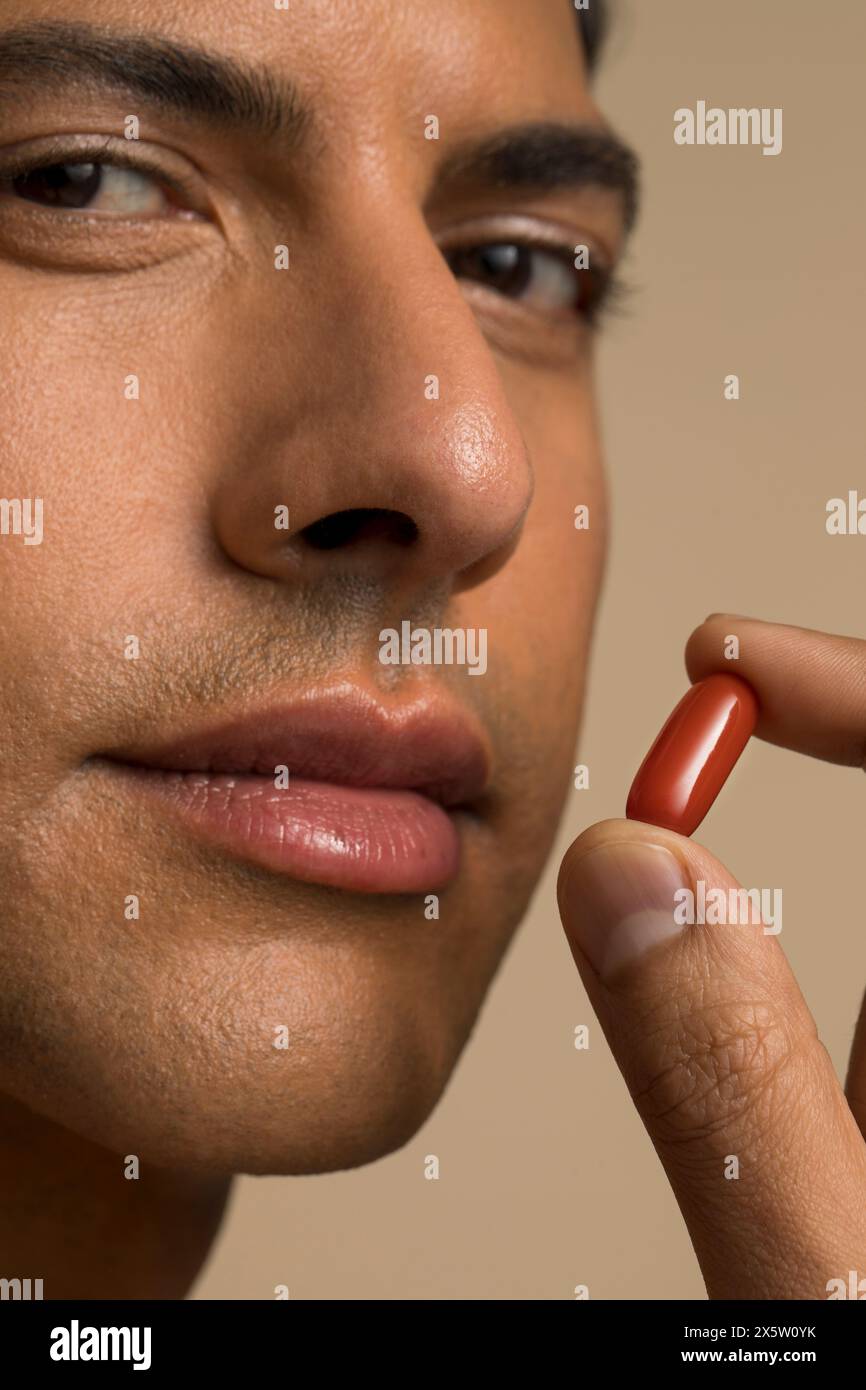 Close-up of man holding nutritional supplement capsule Stock Photo - Alamy