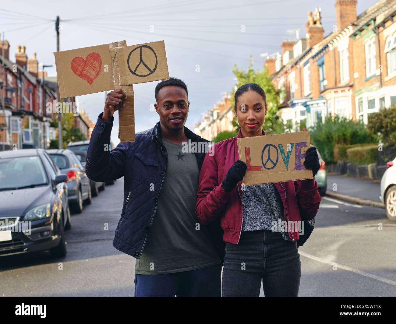 Couple on street holding protest signs with symbols of peace Stock ...