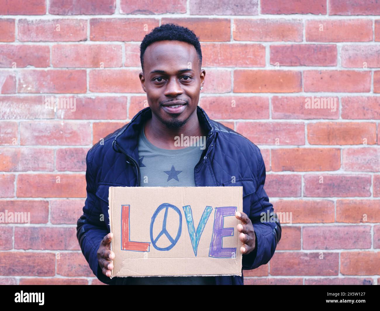 Man holding protest sign with symbol of peace Stock Photo - Alamy