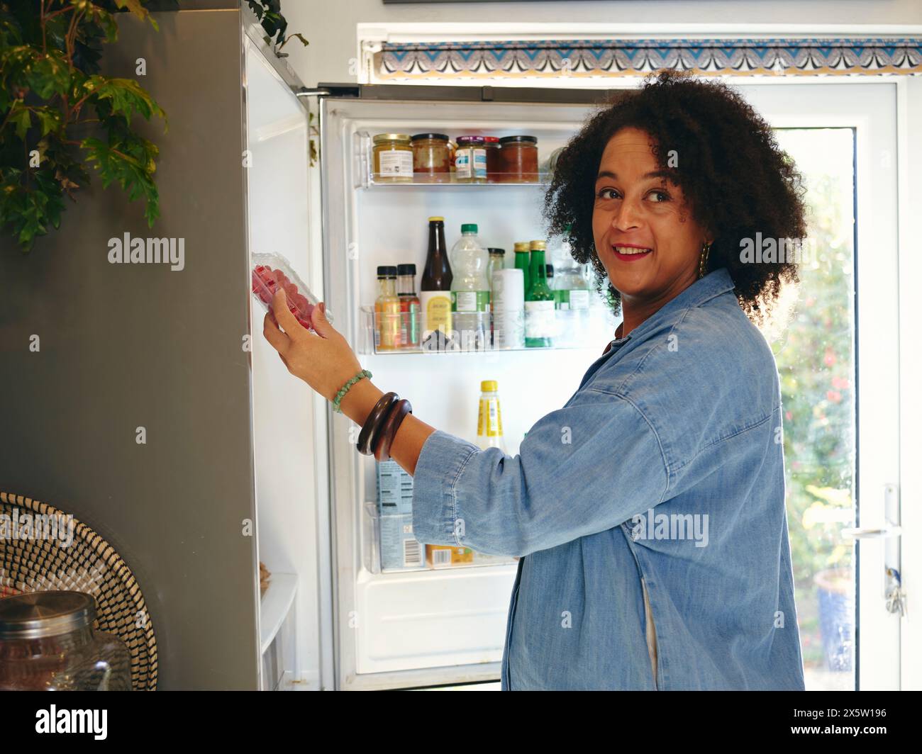 Woman opening kitchen fridge hi-res stock photography and images - Alamy