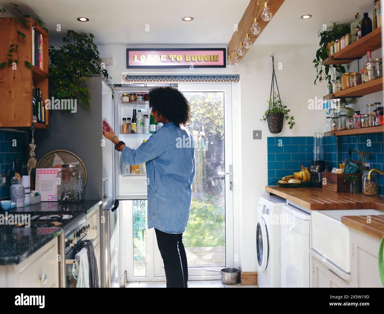 Woman opening fridge Stock Photo - Alamy