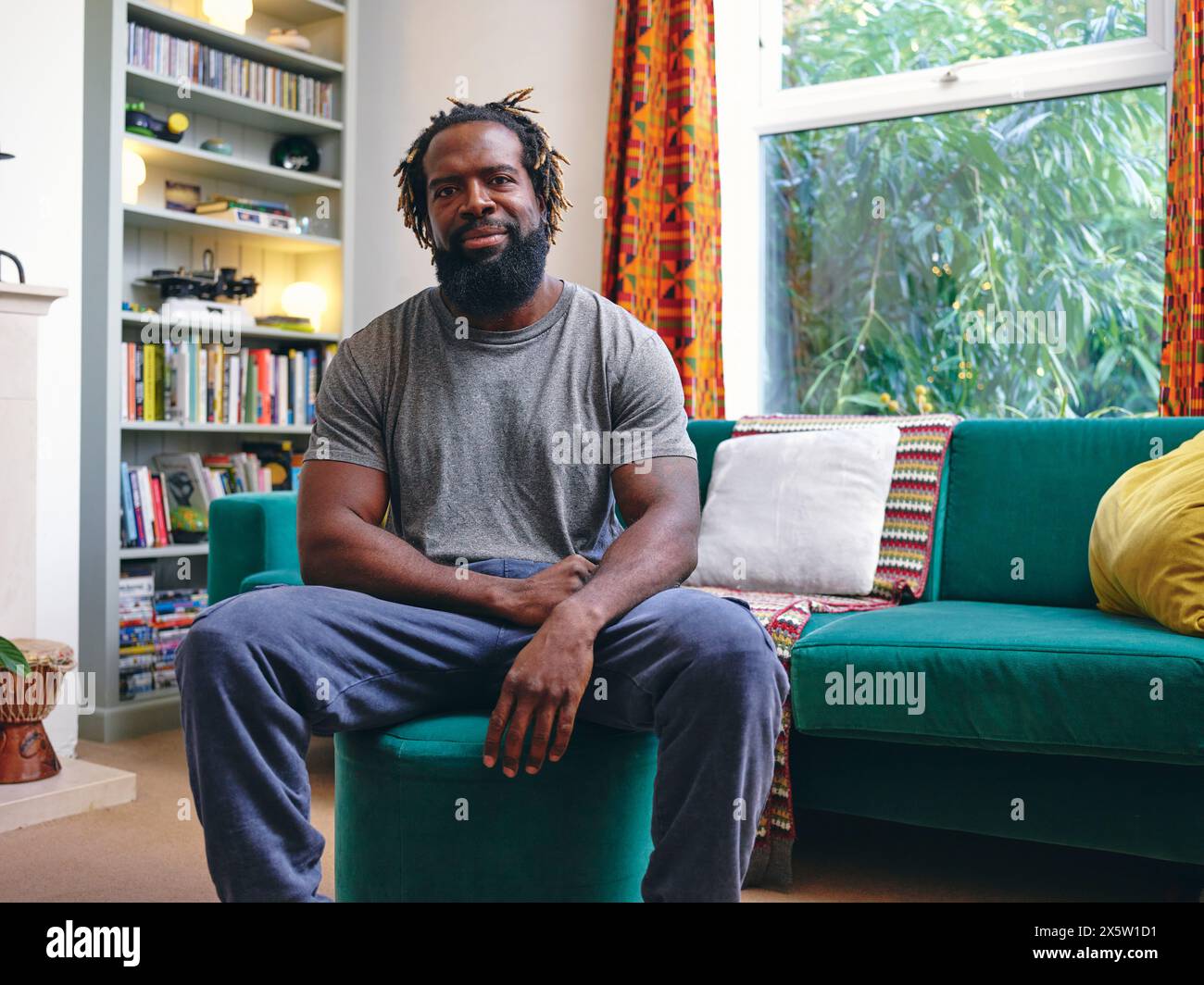 Portrait of man sitting on sofa Stock Photo - Alamy