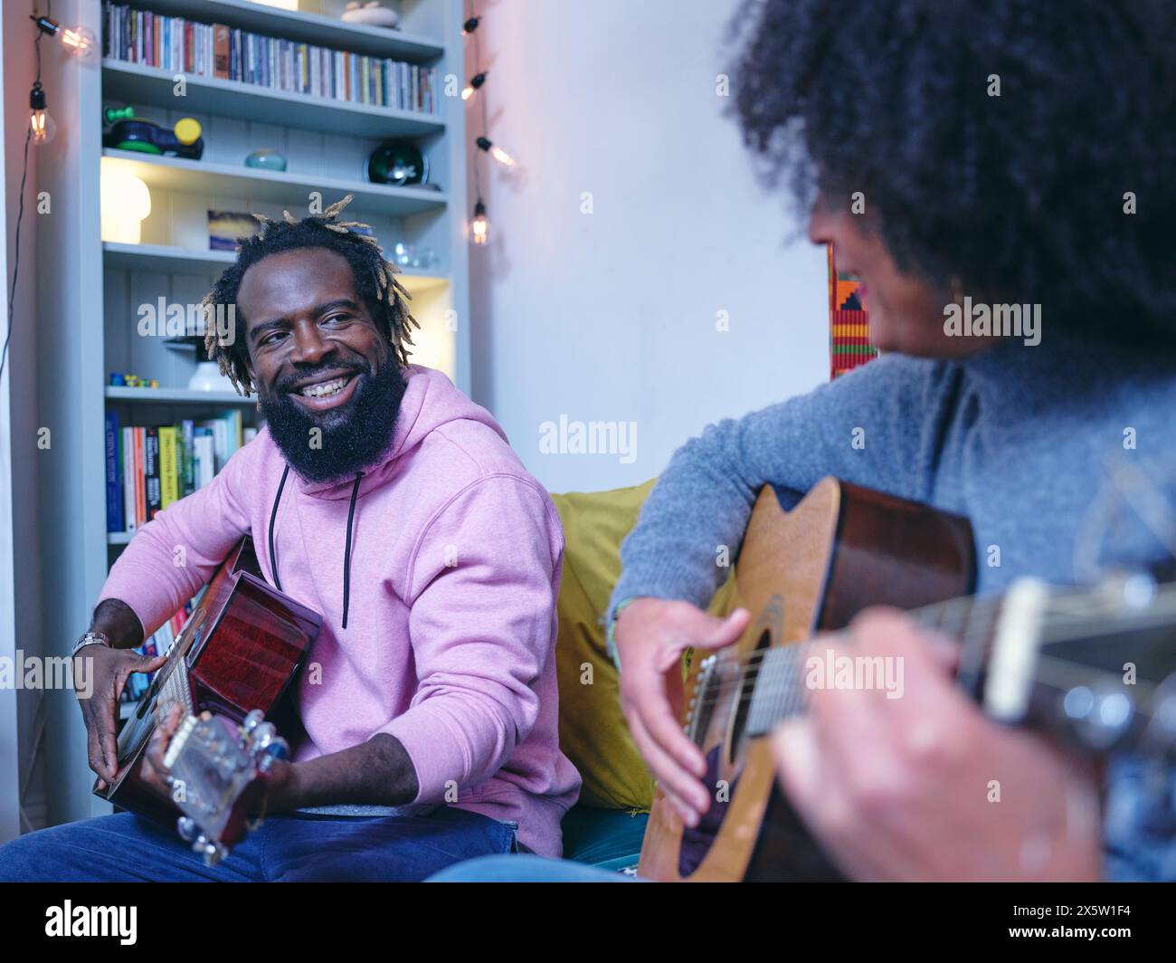 Couple playing acoustic guitars at home Stock Photo - Alamy