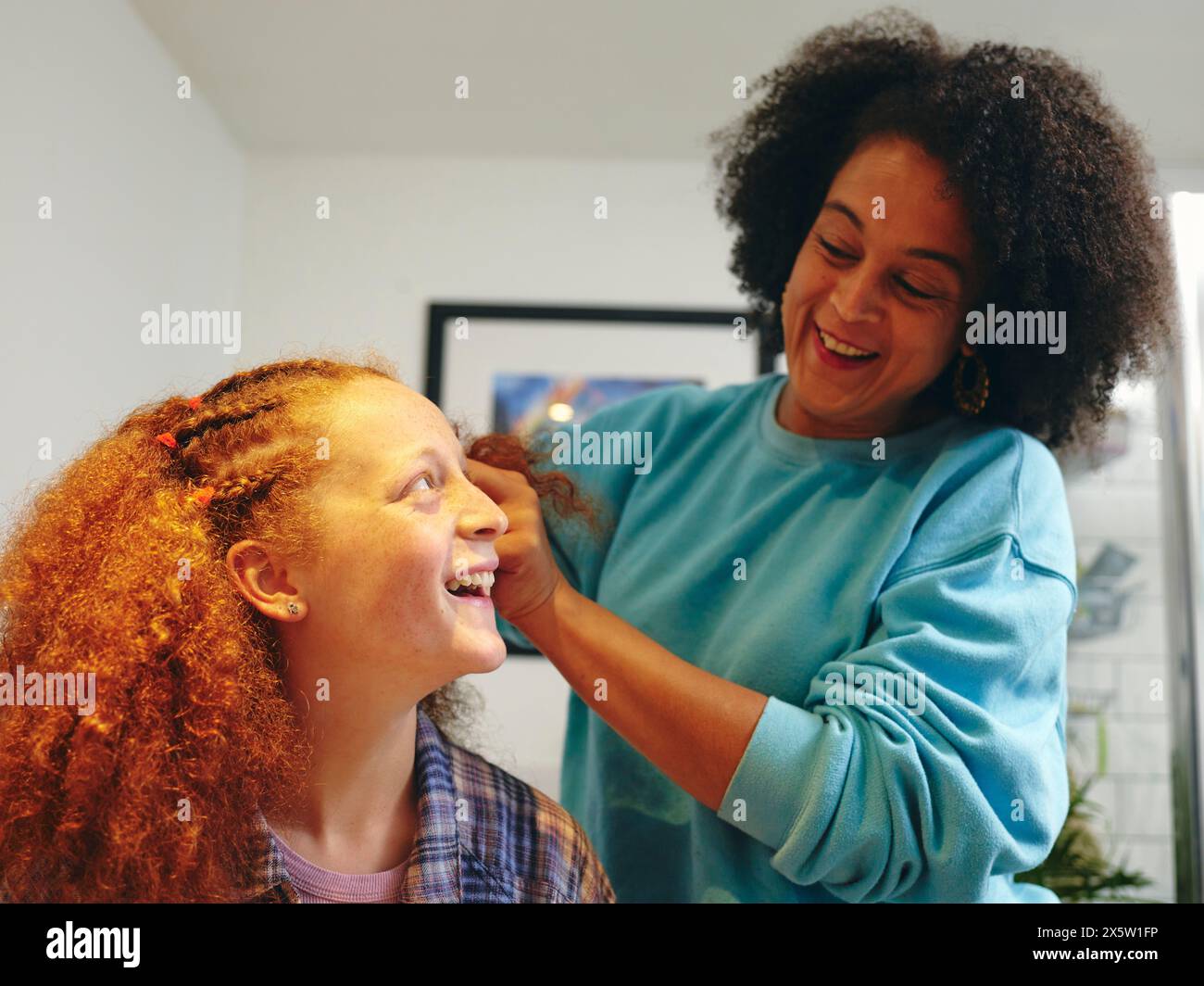Mother fixing daughters hair Stock Photo - Alamy
