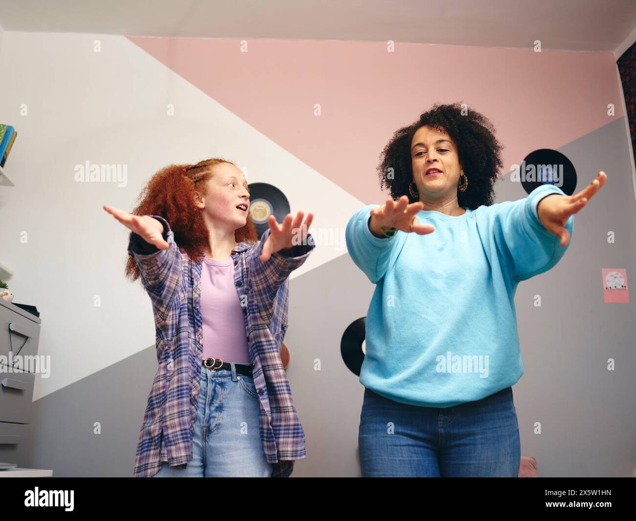 Mother and daughter dancing in room Stock Photo - Alamy