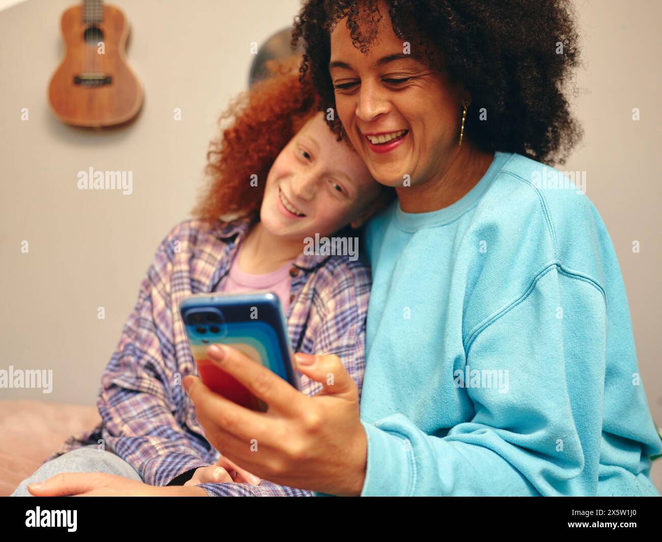 Mother and daughter looking at smartphone Stock Photo - Alamy