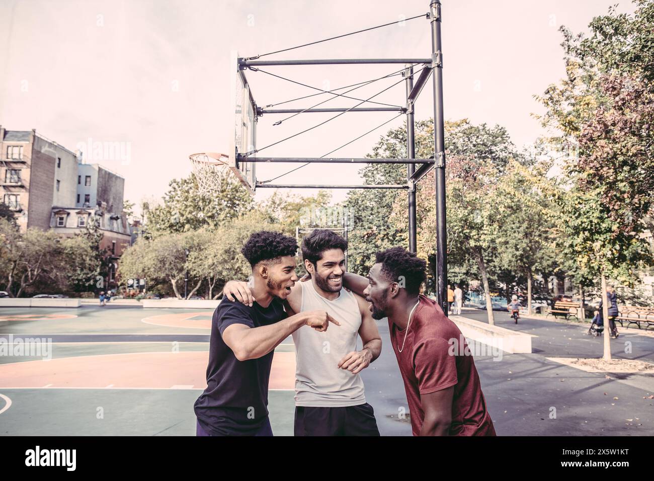 USA, Pennsylvania, Philadelphia, Male friends talking at basketball ...