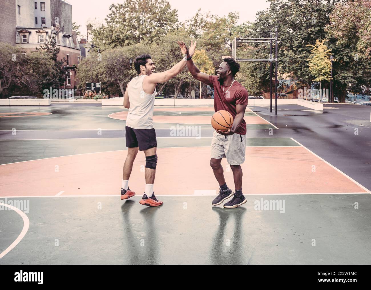 USA, Pennsylvania, Philadelphia, Men giving high five at basketball ...