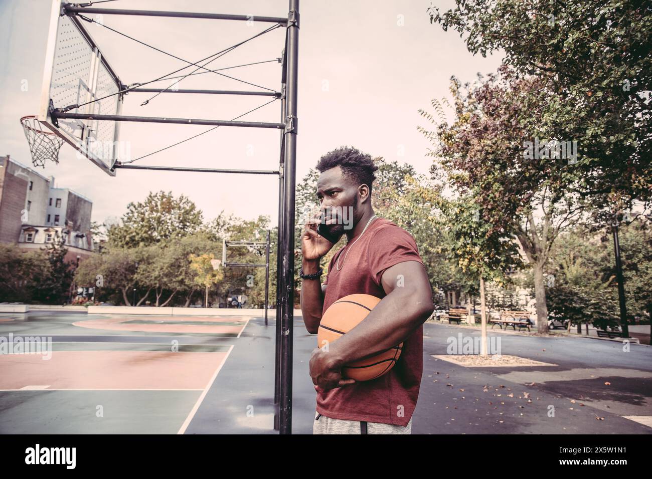 USA, Pennsylvania, Philadelphia, Man using smart phone at basketball ...