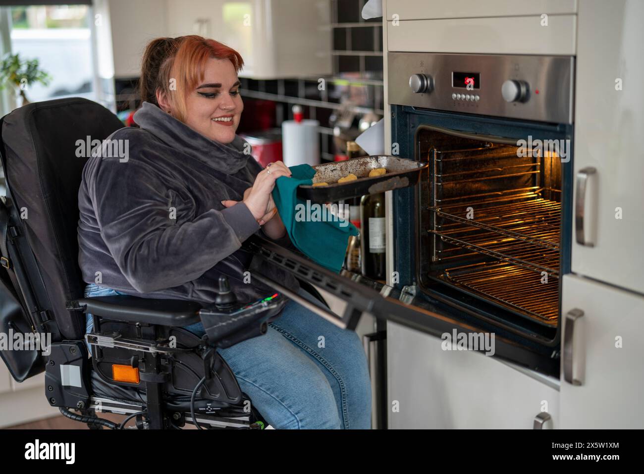 Woman holding baking tray of cookies hi-res stock photography and ...