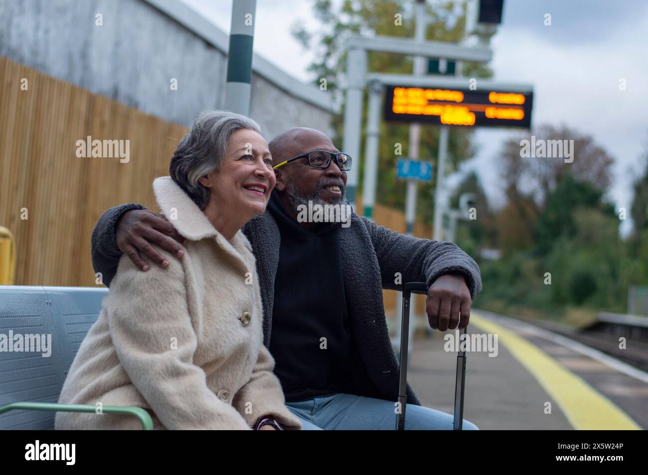 Couple sitting train station hi-res stock photography and images - Alamy
