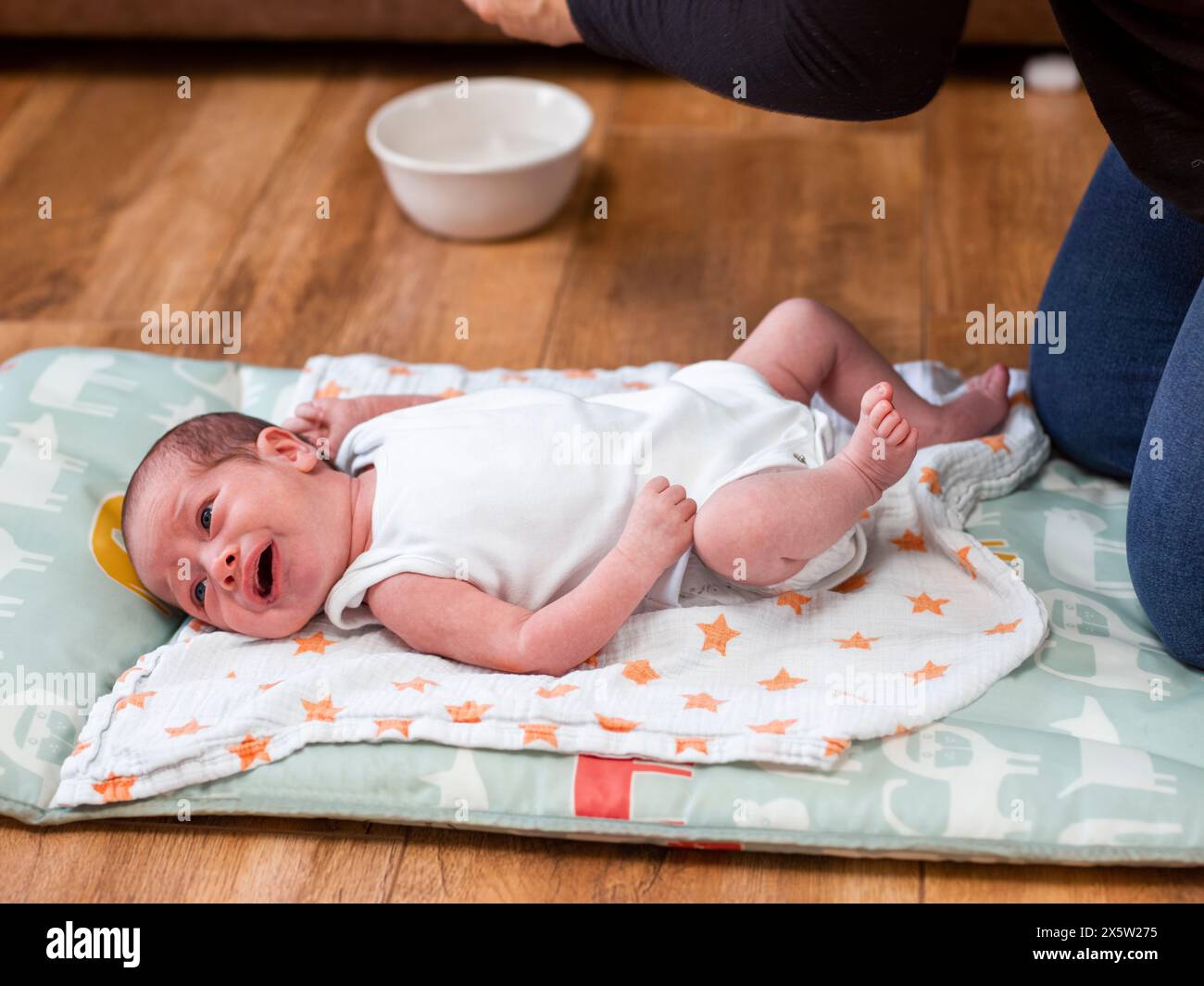 Crying infant girl lying on blanket Stock Photo - Alamy