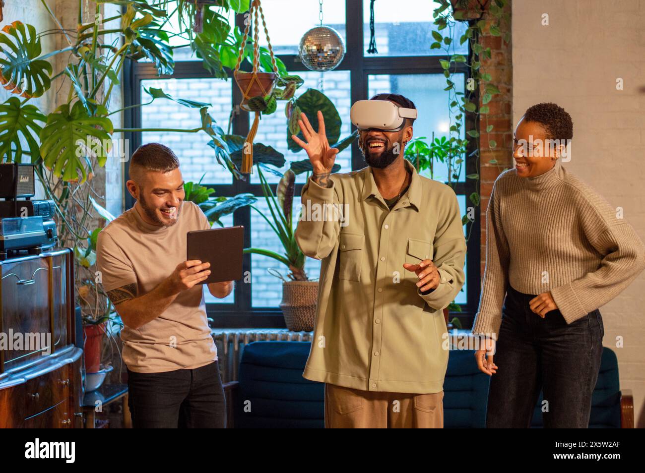Group of friends using virtual reality headset Stock Photo - Alamy