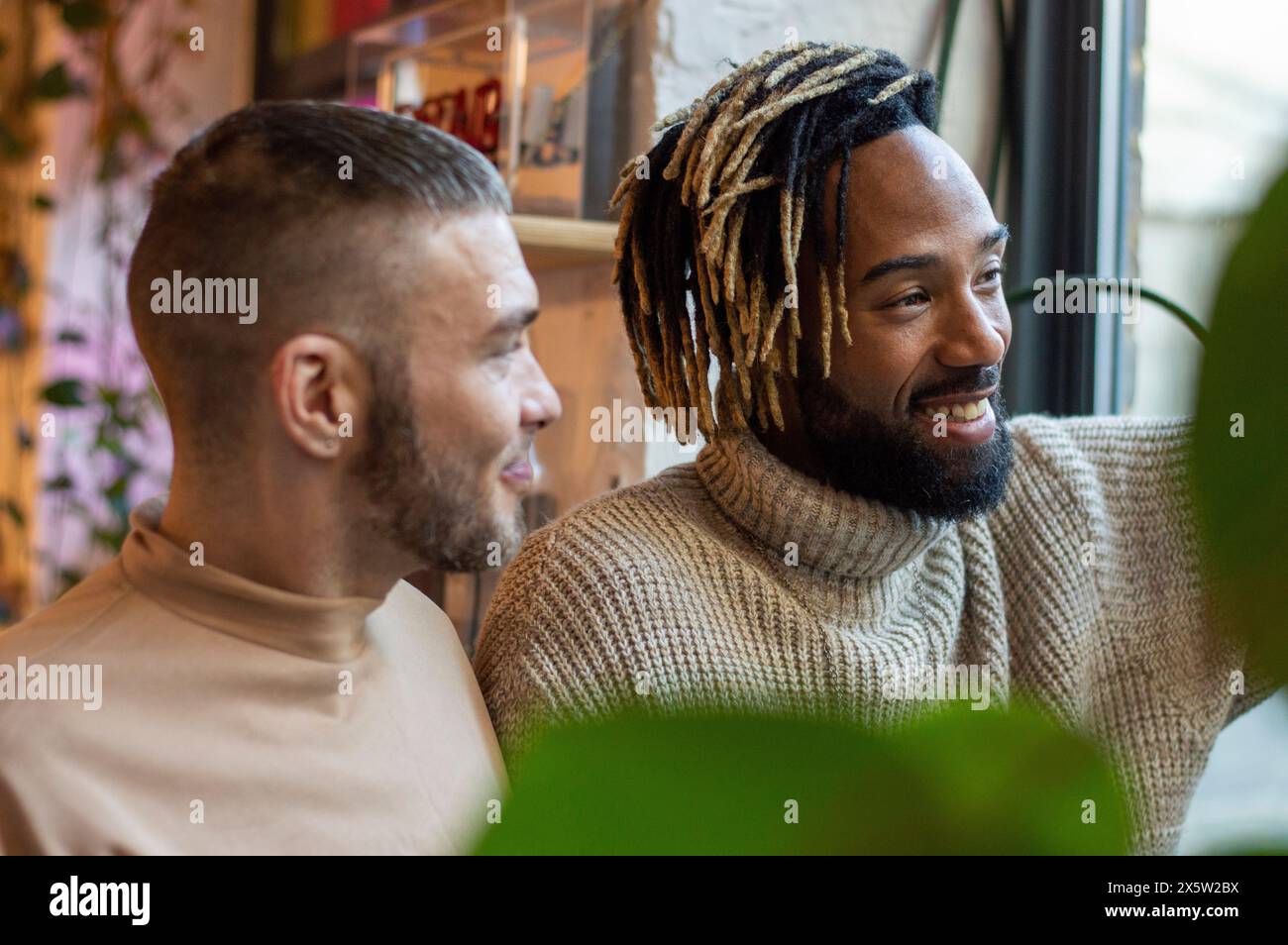 Smiling men looking through window Stock Photo - Alamy