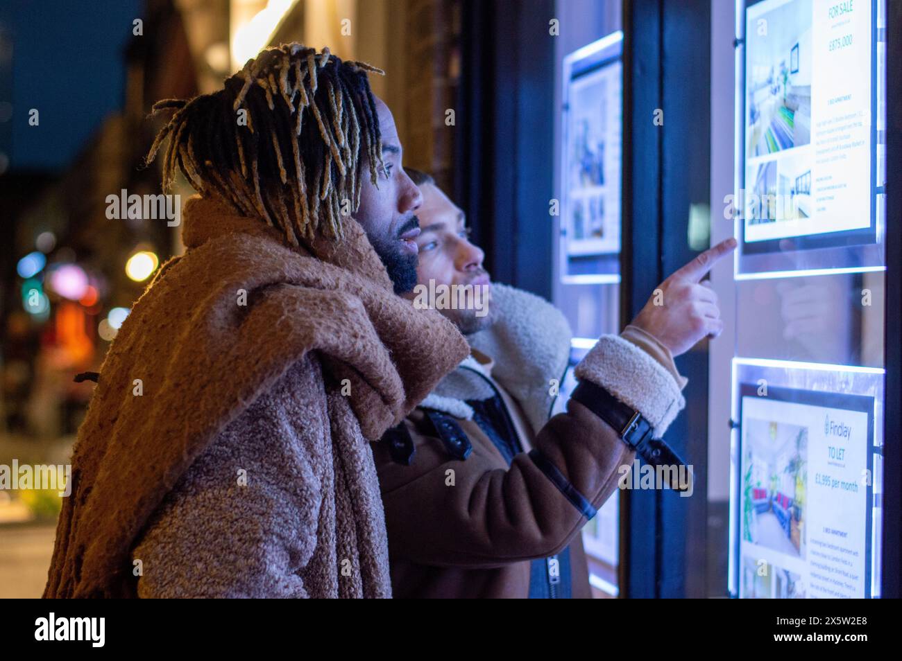 Two men looking at window display Stock Photo - Alamy