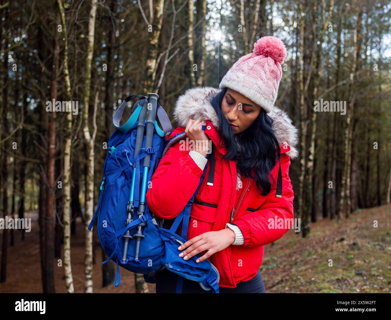 Female hiker putting on backpack Stock Photo - Alamy