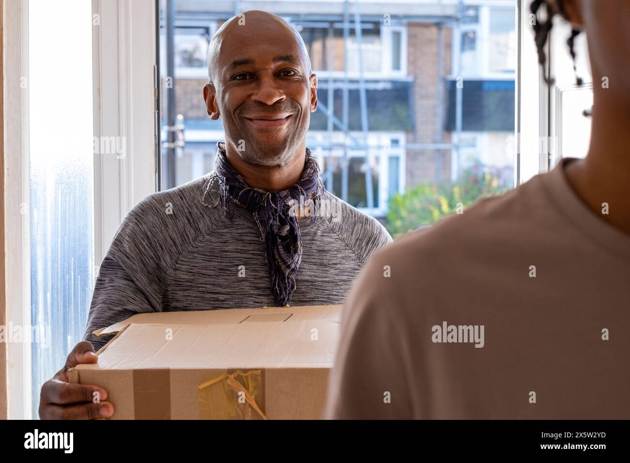 Smiling father and son entering house with cardboard boxes Stock Photo ...