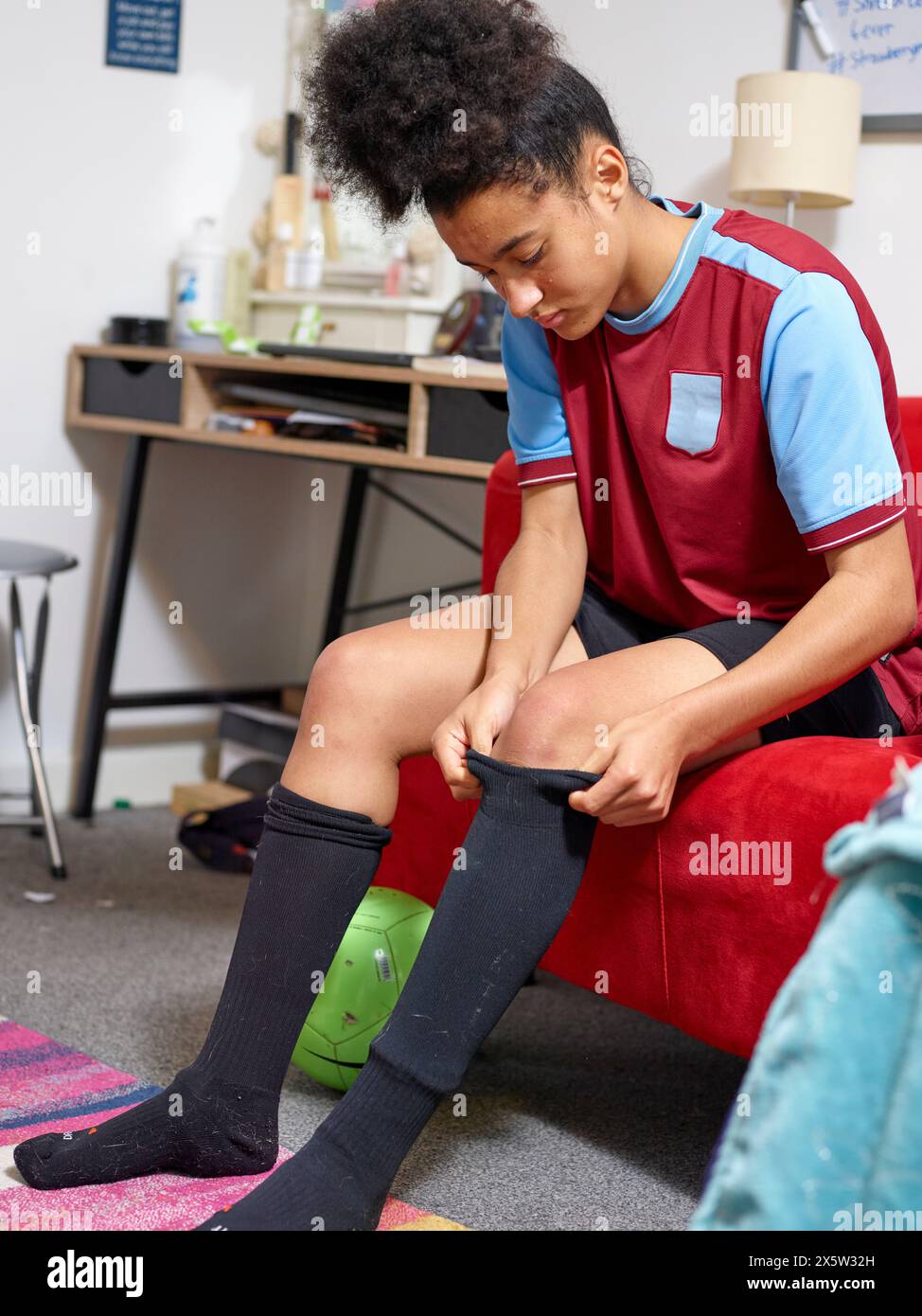 Girl putting on soccer socks Stock Photo - Alamy