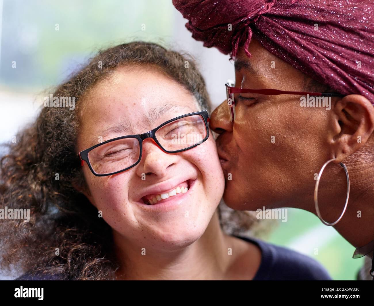 Mother kissing daughter with Down syndrome Stock Photo - Alamy