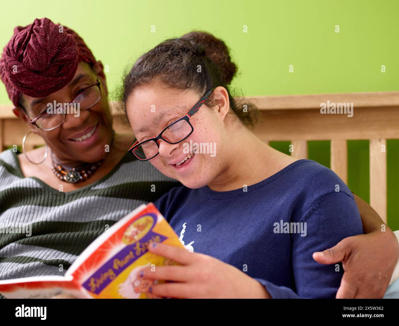Mother and daughter with Down syndrome reading book Stock Photo - Alamy
