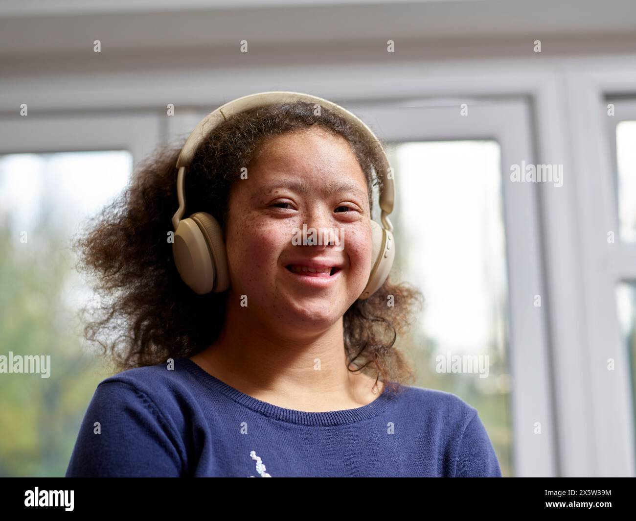 Portrait of smiling girl with Down Syndrome with headphones Stock Photo - Alamy