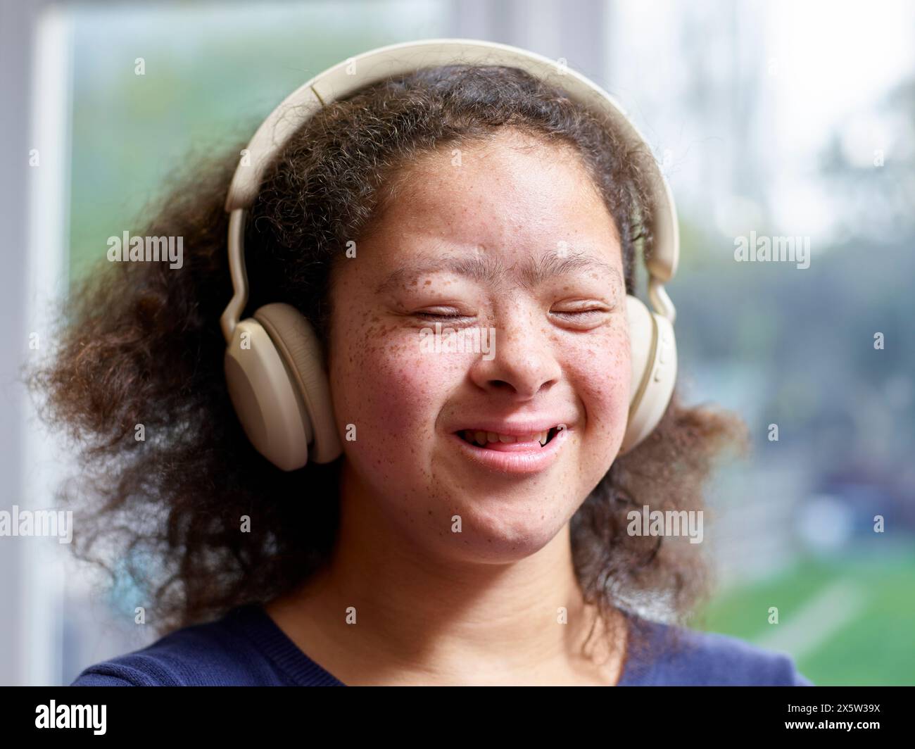 Smiling girl with Down Syndrome with headphones Stock Photo - Alamy