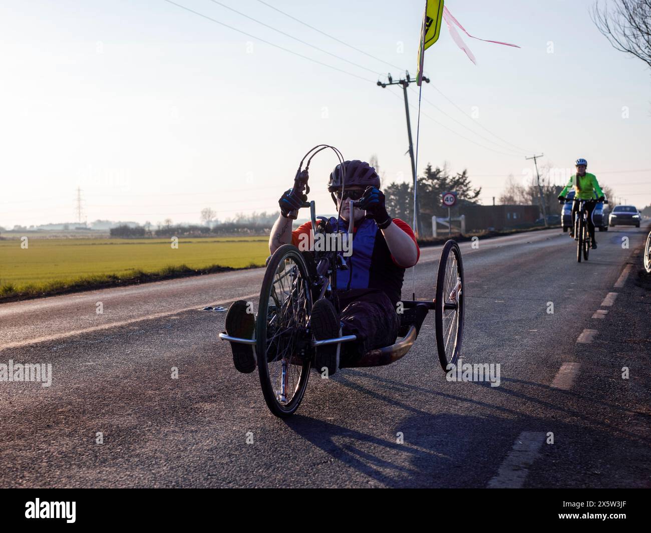 Disabled man riding handcycle on country road Stock Photo - Alamy